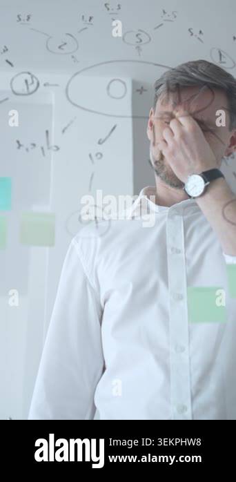 Concentrating businessman in glasses studies hand drawn flowcharts and ...