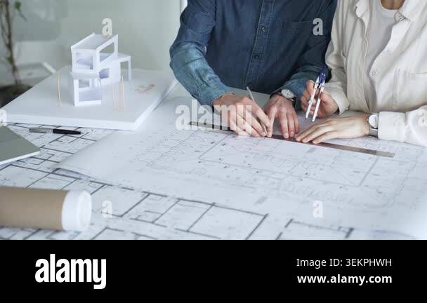 Architects collaborating on building plans, discussing construction ...