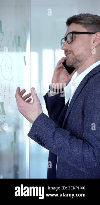 Businessman talking on smartphone while actively gesturing and pointing ...