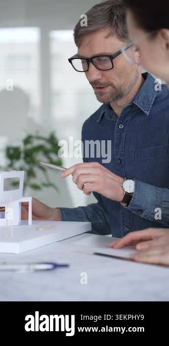 Architectural professionals reviewing blueprints on a desk with a ...