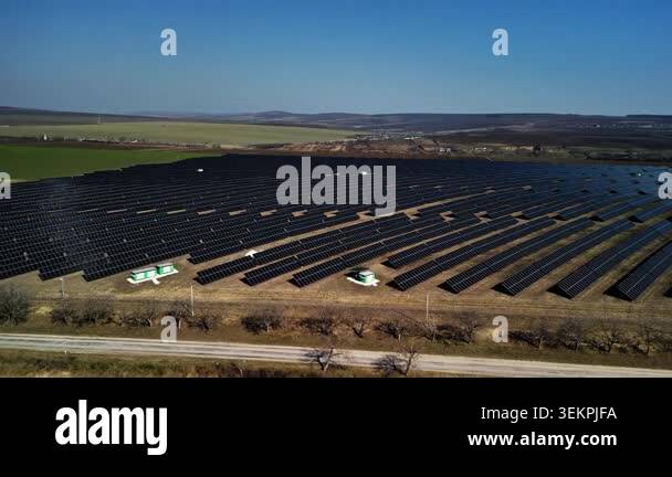 Aerial perspective of a solar panel farm featuring numerous ...