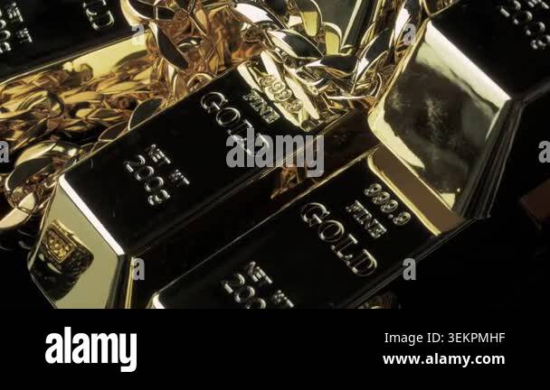 4K video of spinning gold bullion bars and a heavy gold chain in ...