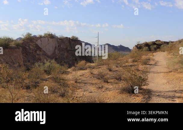 Desert trail near Tapatio cliffs, surrounded by rugged rocky hills ...
