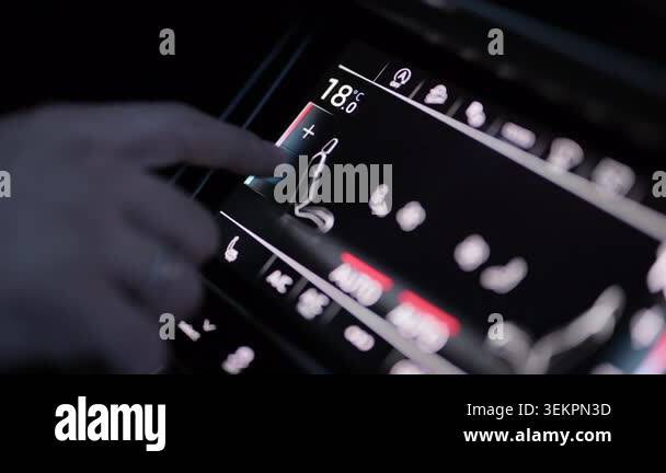 A hand adjusts the climate control system in a car. Male hand ...