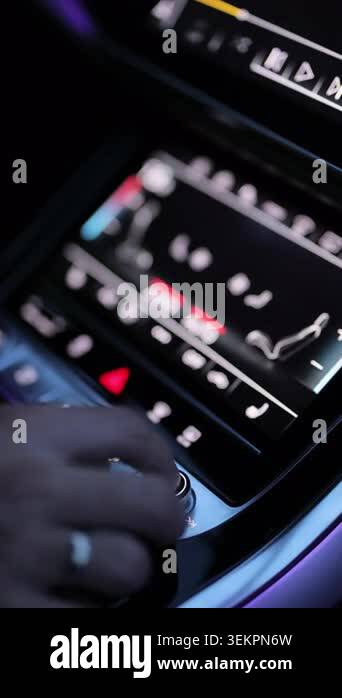 Vertical video of car dashboard volume knob. Drivers hand adjusts ...