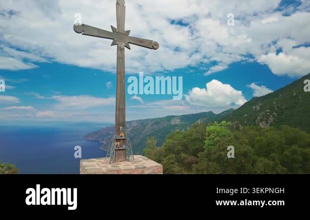 Aerial drone footage of a large wooden cross standing on a stone ...