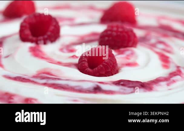 Juicy ripe raspberry on smooth white yogurt with soft texture and ...