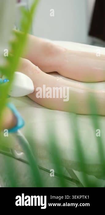Beauty master makes laser hair removal epilation of legs skin close-up ...
