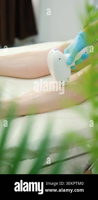 Beauty master makes laser hair removal epilation of legs skin close-up ...