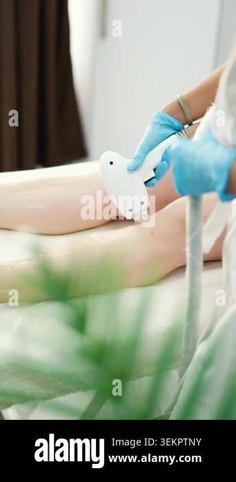 Beauty master makes laser hair removal epilation of legs skin close-up ...