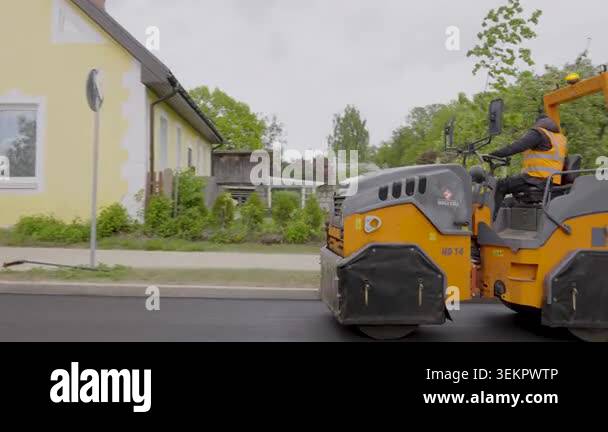Valmiera, Latvia - May 28, 2026: Road construction worker drives a ...