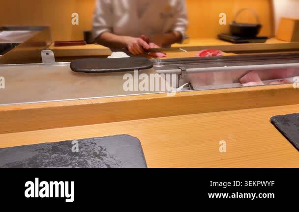 Professional sushi chef slicing raw scallop with Yanagiba knife. Master ...