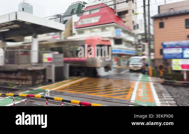 A pink train of the Keio Inokashira line arrives at Shimokitazawa ...