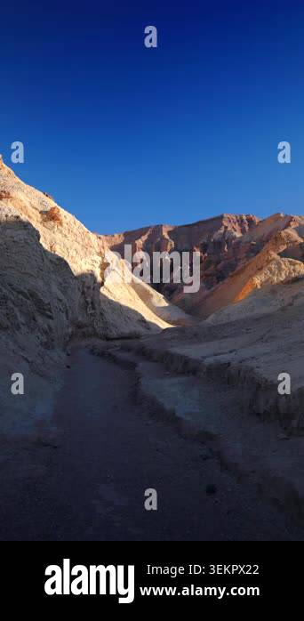 Vertical Screen: Man with backpack hiking through Golden Canyon in ...