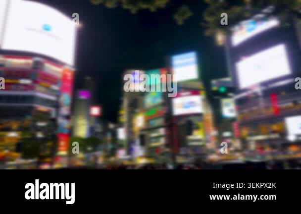 Shibuya Crossing at night with bright neon lights and giant advertising ...