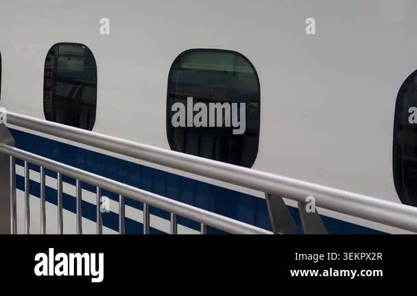 A modern Japanese Shinkansen bullet train stops at Shin-Osaka station ...