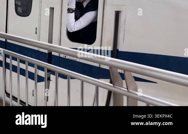 A modern Japanese Shinkansen bullet train stops at Shin-Osaka station ...