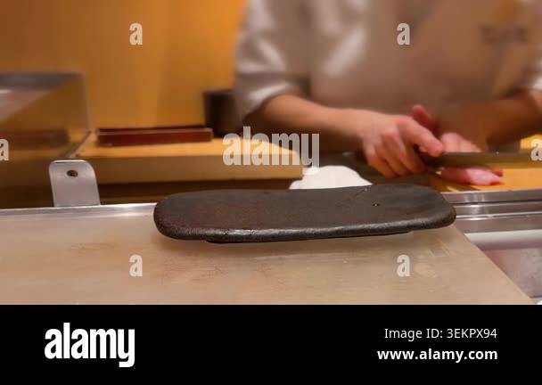 Professional sushi chef slicing raw scallop with Yanagiba knife. Master ...