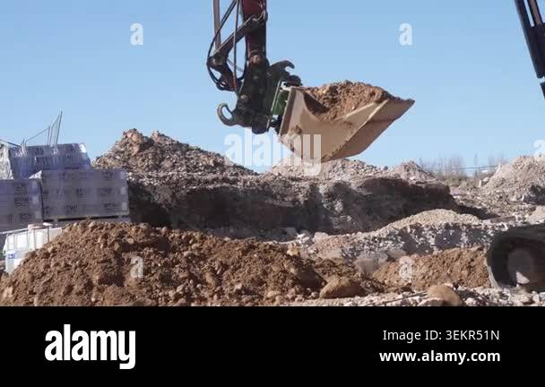 Tracked excavator working with ground soil on a building site ...