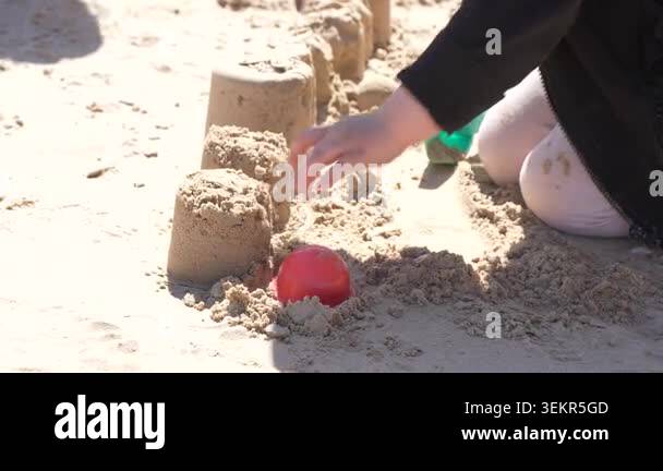 structured sand pies with unrecognizable toddlers digging in background ...