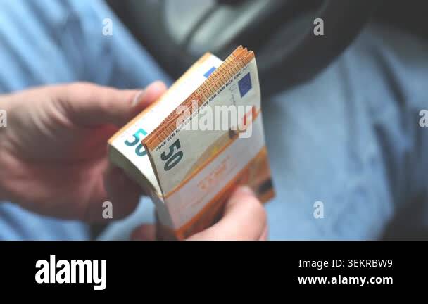 Detailed video footage of a person holding a thick pack of fifty euro ...