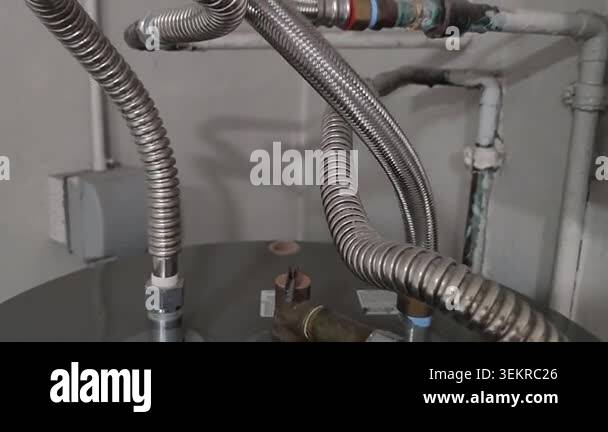 Utility room interior featuring flexible metal plumbing lines and pipe ...