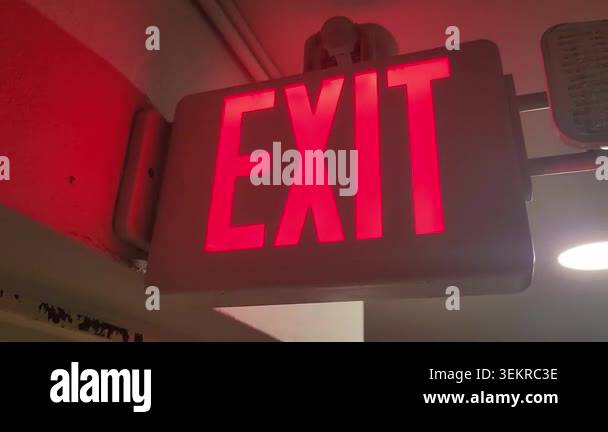 Bright red illuminated EXIT sign mounted indoors with integrated ...