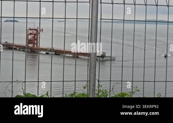 Balikpapan bay view from Balang island bridge.Fence bars frame a ...