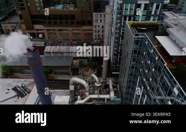 Aerial drone top view of rooftop steam plant with smokestack in ...