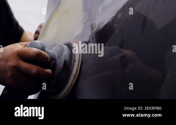 Close-up of car polishing and sanding process in an auto repair shop ...