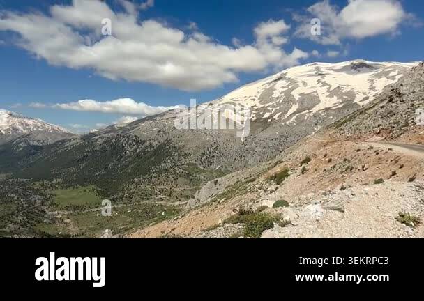 Mountainous dirt road. Rocky snowy mountains. Mountainous winding road ...