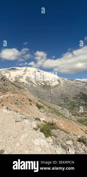 Mountainous dirt road. Rocky snowy mountains. Mountainous winding road ...