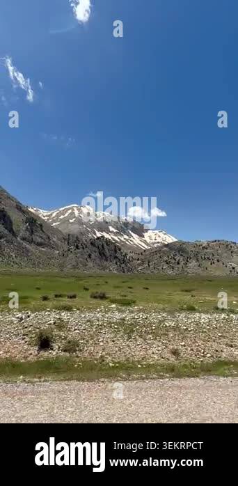 Mountainous dirt road. Rocky snowy mountains. Mountainous winding road ...