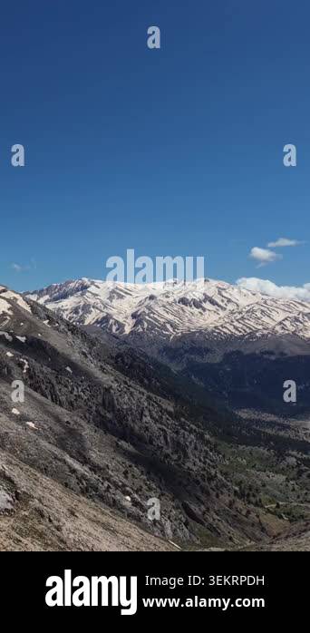 Mountainous dirt road. Rocky snowy mountains. Mountainous winding road ...