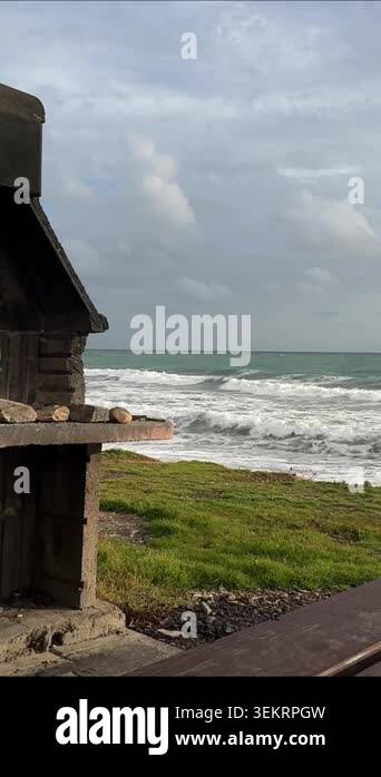 barbecue on a green lawn by the sea. Waves cloudy beach. Waves crashing ...