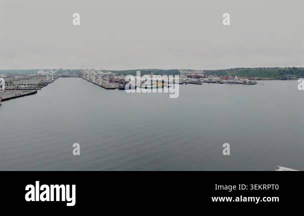 Aerial drone approach toward container port with cargo cranes shipping ...