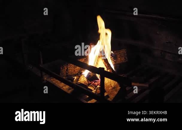 A close-up macro video of intense orange and red glowing embers on a ...