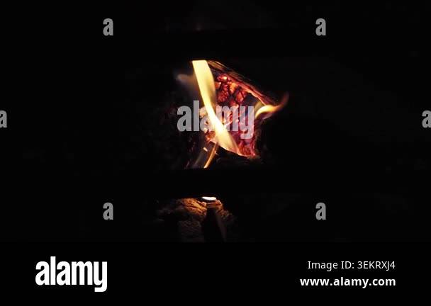 A close-up macro video of intense orange and red glowing embers on a ...