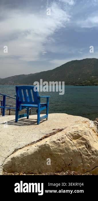 Blue chair standing on beach with beautiful view of mountains and sea ...