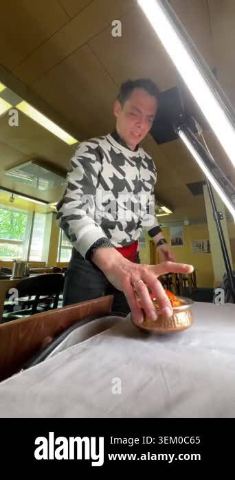 Caucasian man directing tabletop food shoot, animated gestures and ...