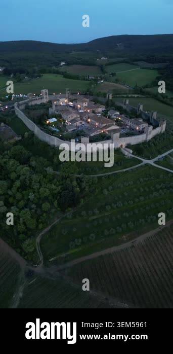 Aerial view of the illuminated medieval walled town of Monteriggioni in ...