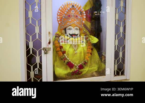 holy khatu shyam ji statue adorned with flowers and traditional ...