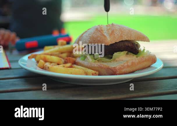 Fresh burger and crispy fries plated at open air restaurant ...