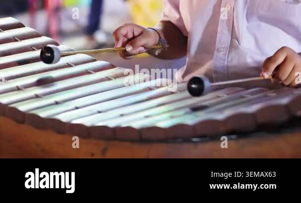 Hands playing a wooden xylophone with mallets, Thai school students ...