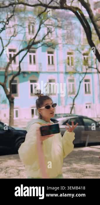 Latina creator demonstrating dance moves, playful street performance ...