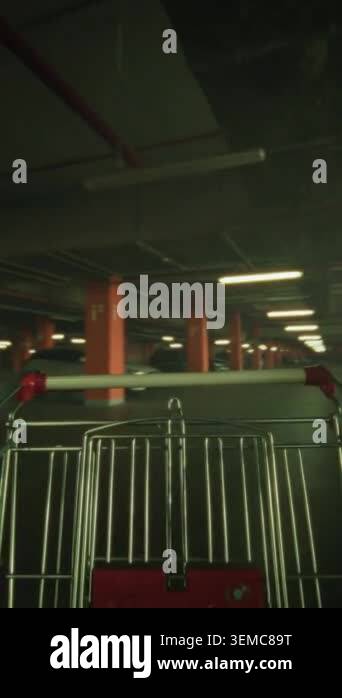 Shopping cart gliding through underground parking. Closeup POV of metal ...