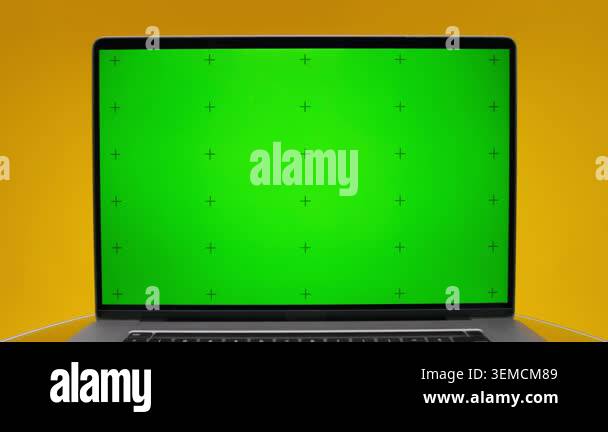 Open laptop with green screen tracking markers on yellow studio ...