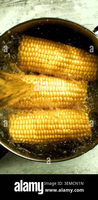 Water pours into a pot with corn. View from above. Filmed on a high ...