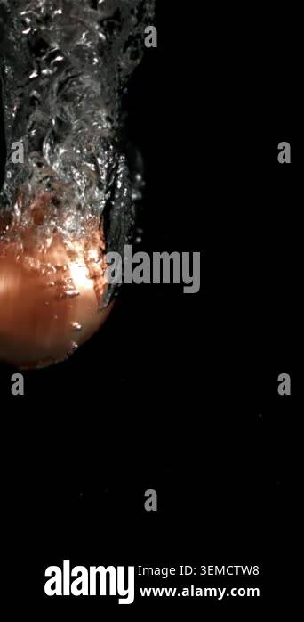 Onion falls under water. Filmed is slow motion 1000 fps. High quality ...