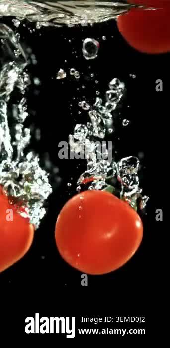 Tomatoes fall under water. Filmed on a high-speed camera at 1000 fps ...